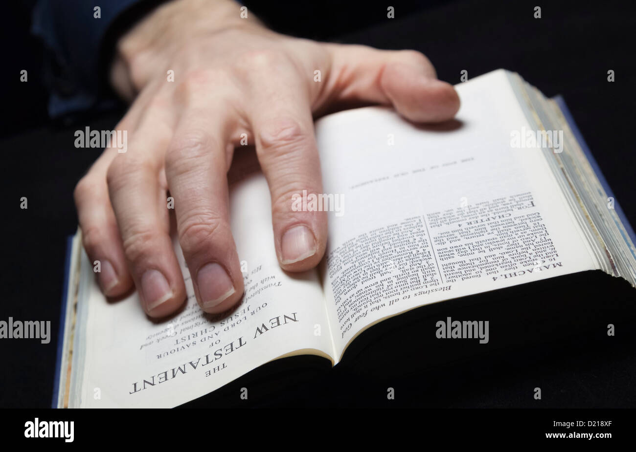A man reading the Holy Bible with one hand Stock Photo - Alamy