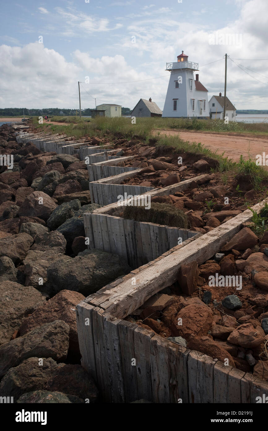 Zigzag wooden sea defences on the beach with the lighthouse in the ...
