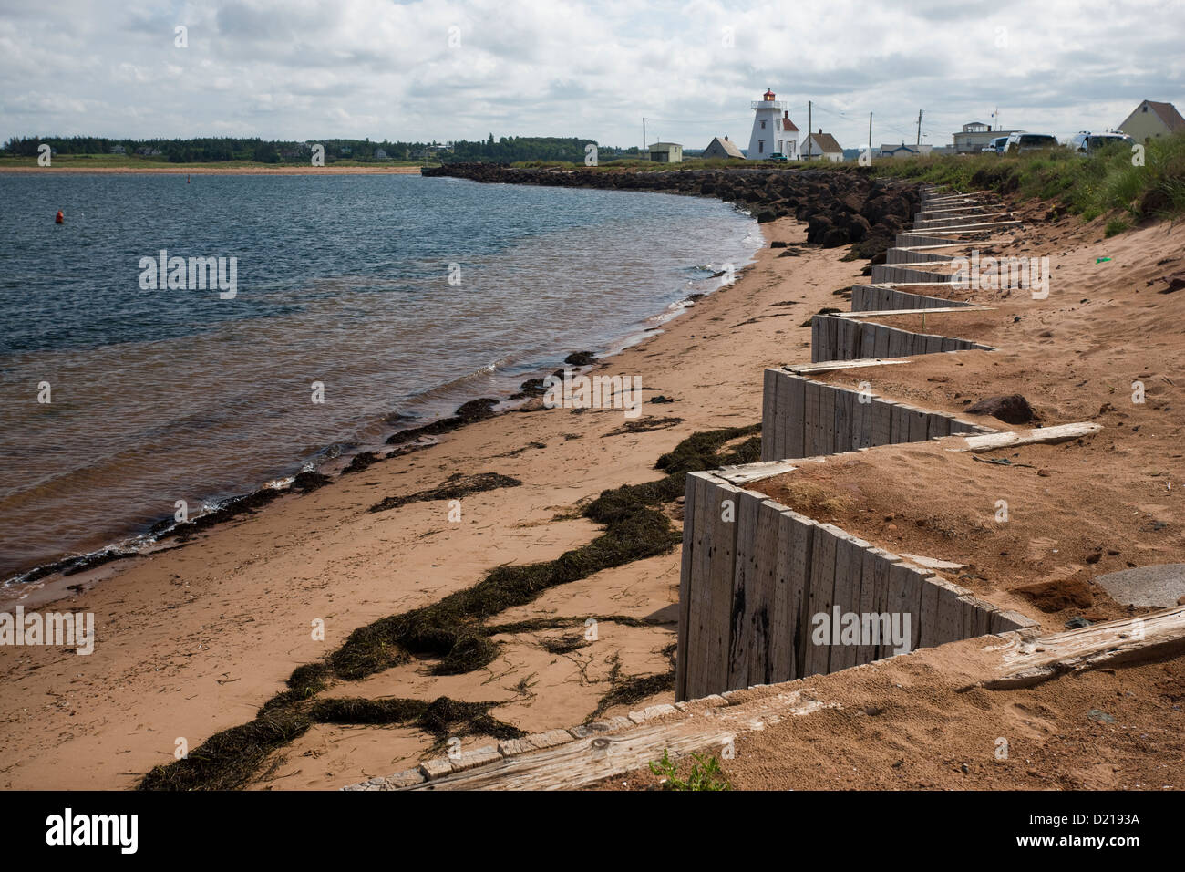 Zigzag wooden sea defences on the beach with the lighthouse in the ...