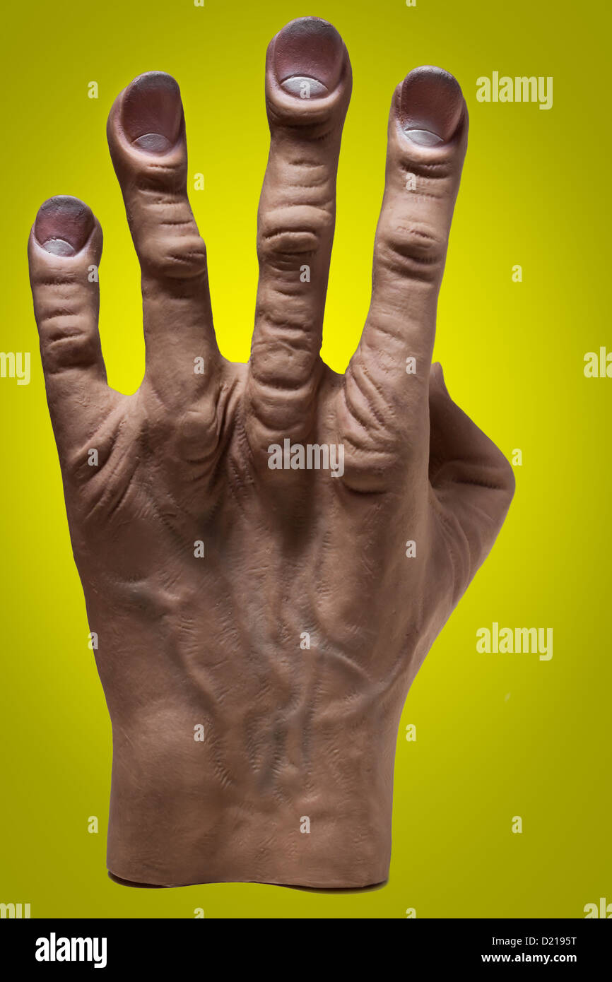 Huge fake hand standing on yellow background Stock Photo - Alamy