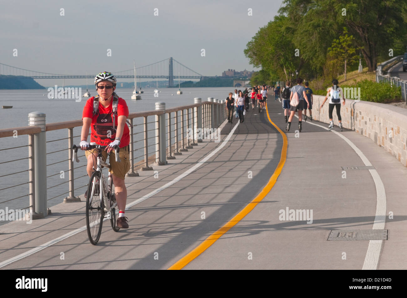 Woman riding a bicycle on Riverwalk in Riverside Park Stock Photo - Alamy