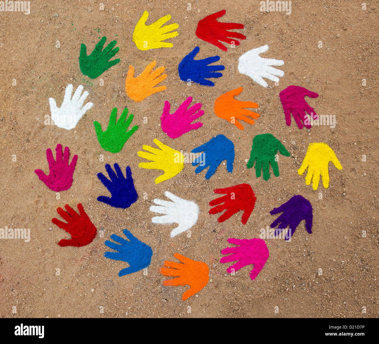 Coloured powder hand prints in a circular spiral pattern on a dirt ...