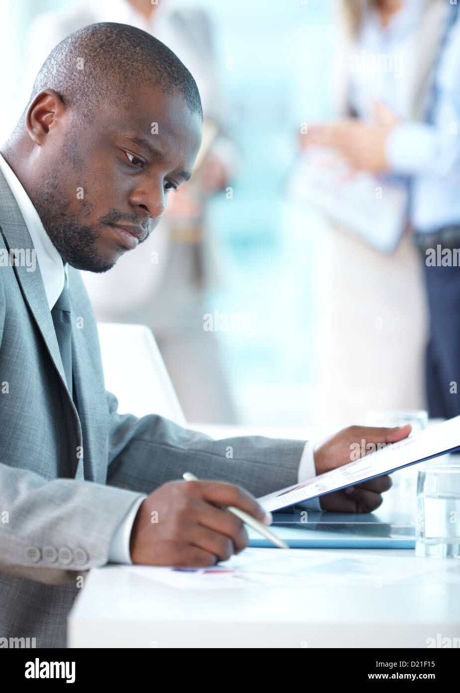 Vertical image of a serious businessman being concentrated on his work ...