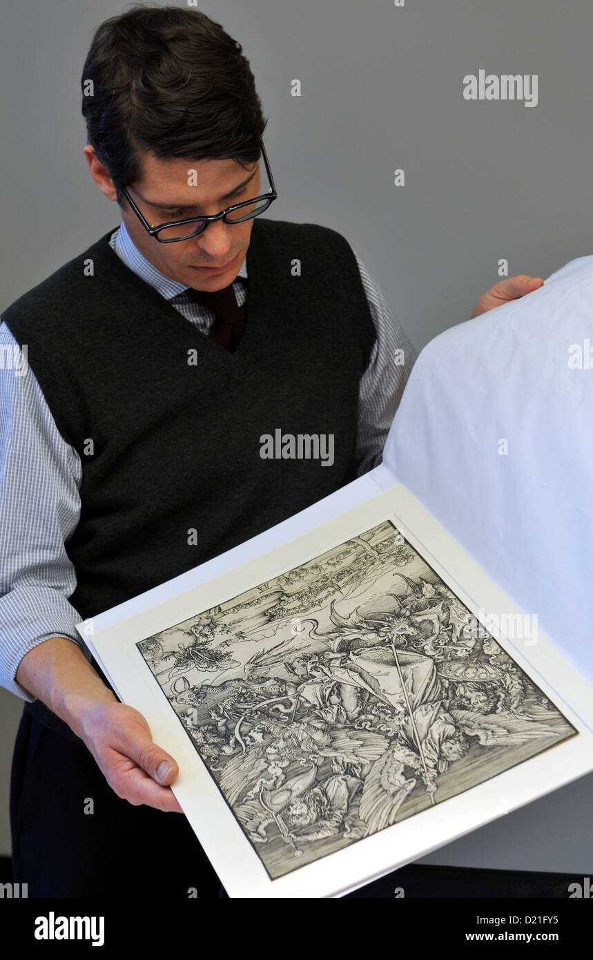 Christie's employee Tim Schmelcher holds the woodcut 'St Michael ...