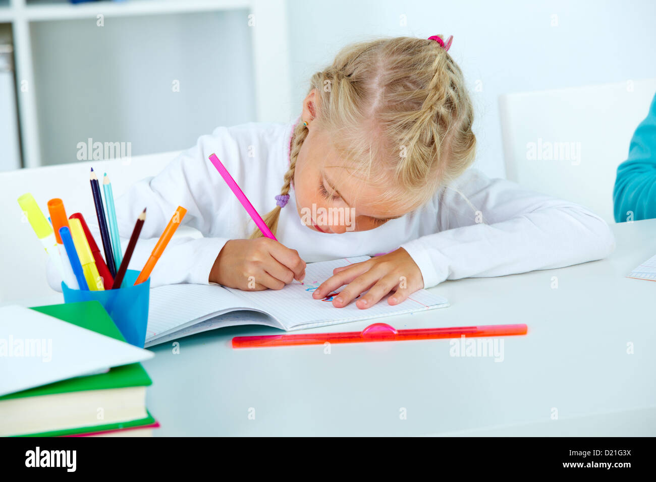 Diligent pupil drawing in her workbook Stock Photo - Alamy