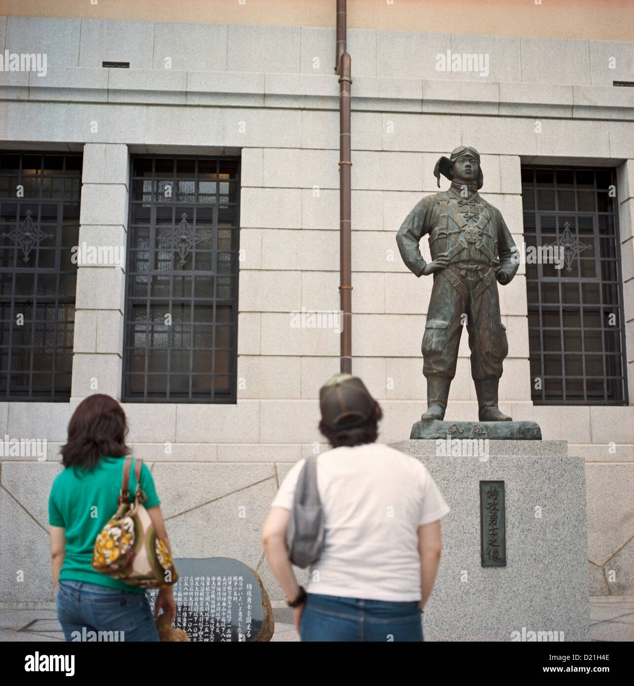 Visitors look at the statue of a Kamikaze pilot at the Yasukuni Shrine ...