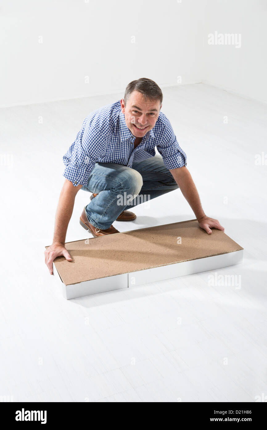 Mature man building shelf, smiling Stock Photo - Alamy