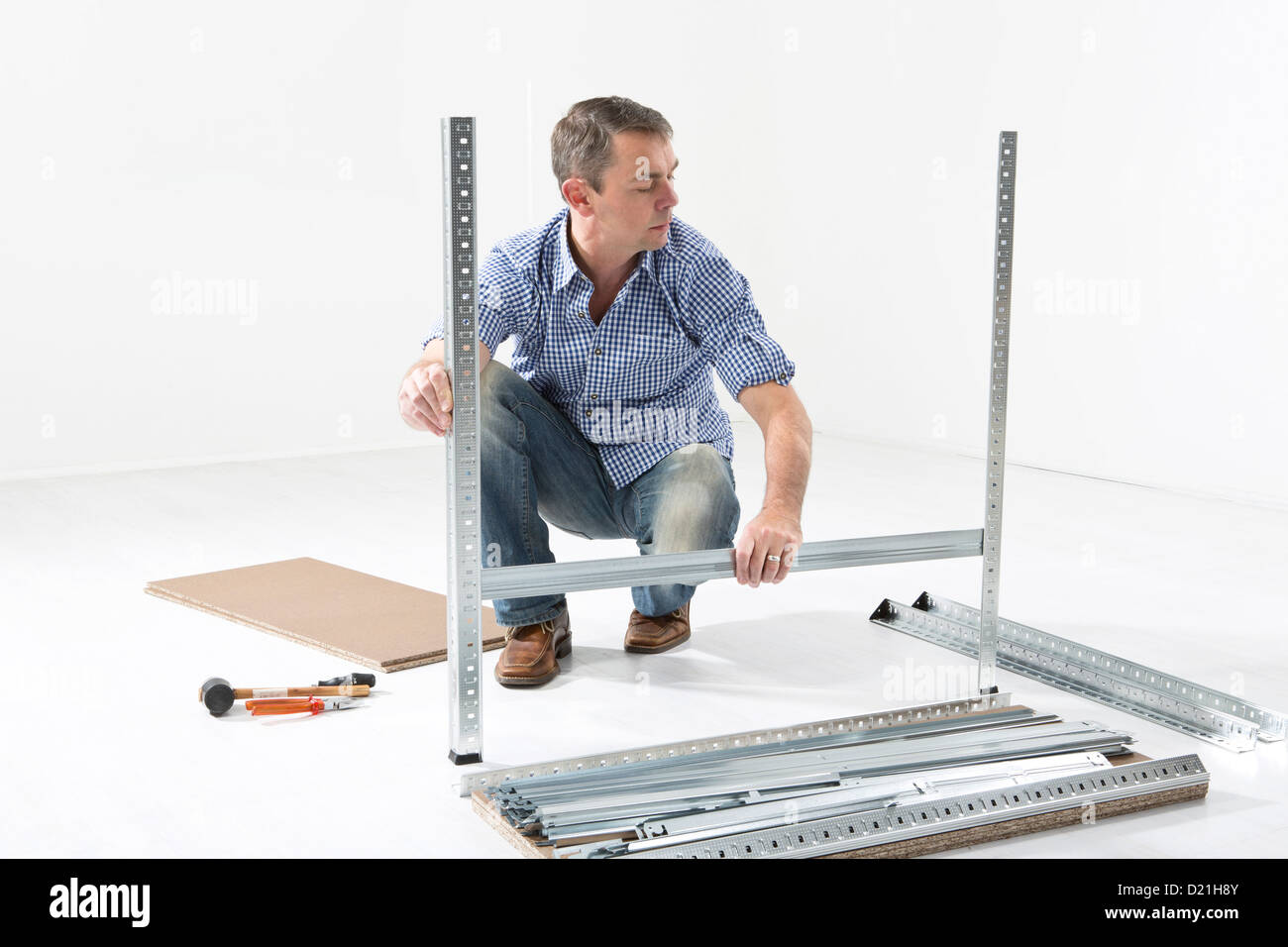 Mature man building shelf Stock Photo - Alamy
