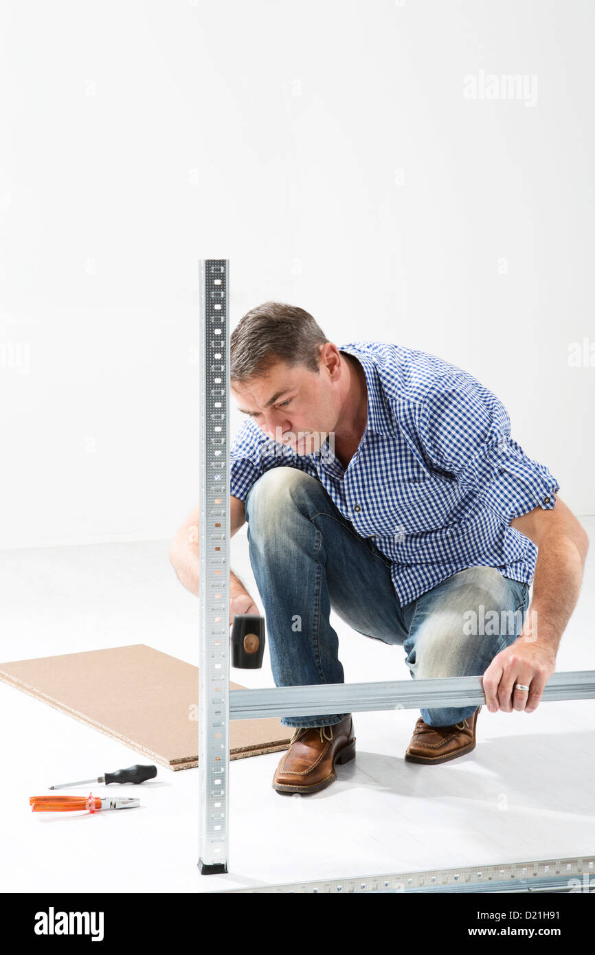 Mature man building shelf Stock Photo - Alamy