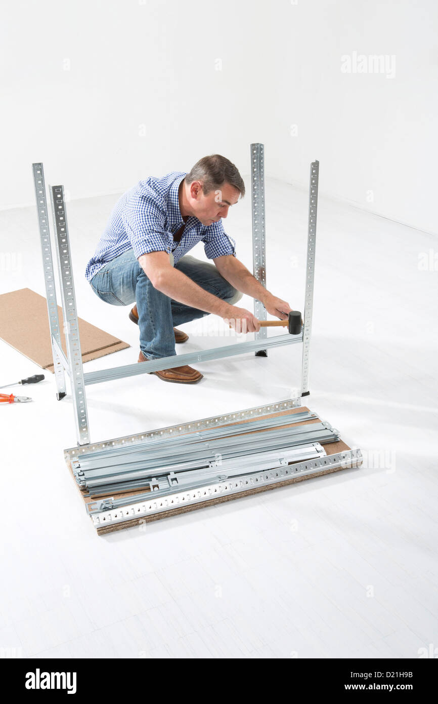 Mature man building shelf Stock Photo - Alamy