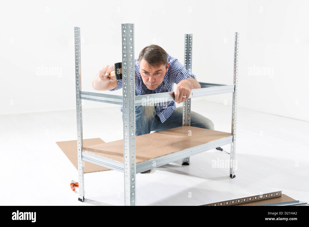Mature man building shelf Stock Photo - Alamy