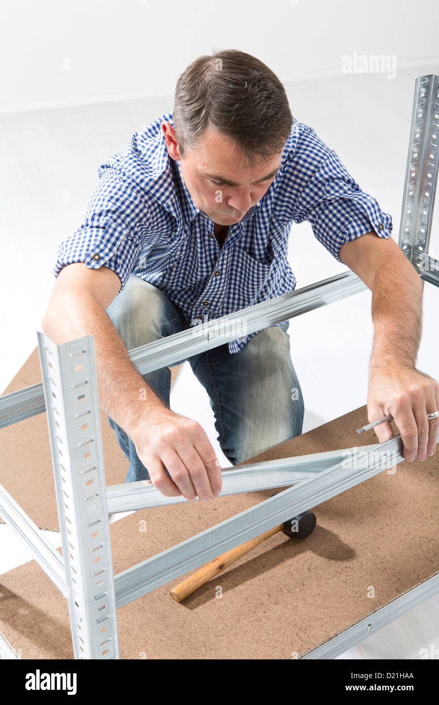 Mature man building shelf Stock Photo - Alamy
