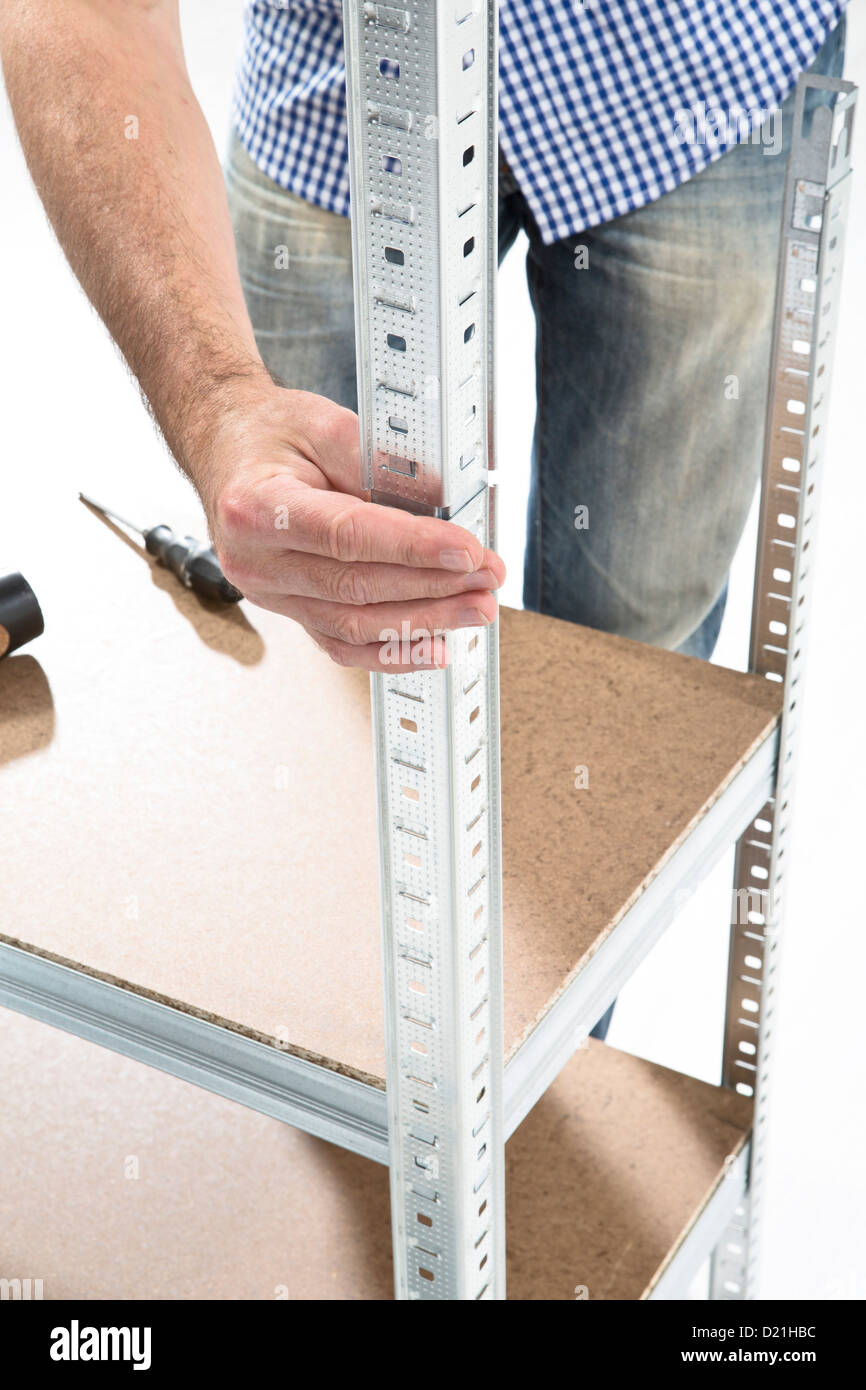 Mature man building shelf Stock Photo - Alamy