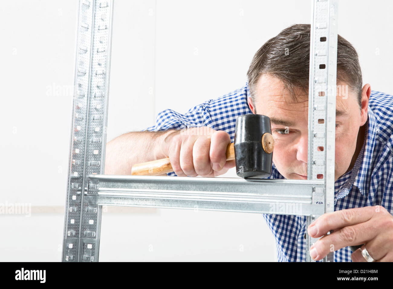 Mature man building shelf Stock Photo - Alamy