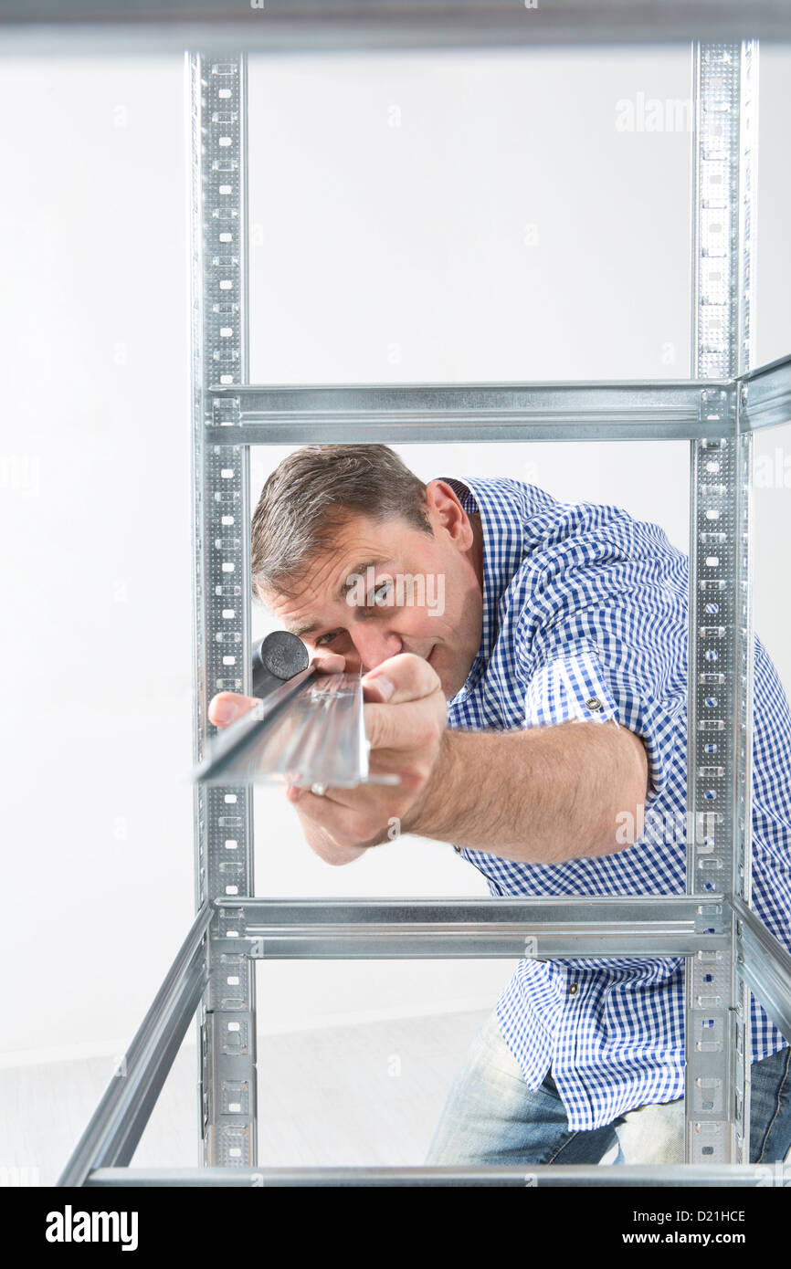 Mature man building shelf Stock Photo - Alamy