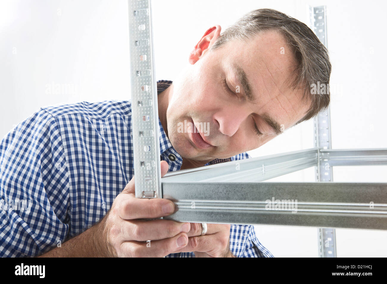 Mature man building shelf Stock Photo - Alamy