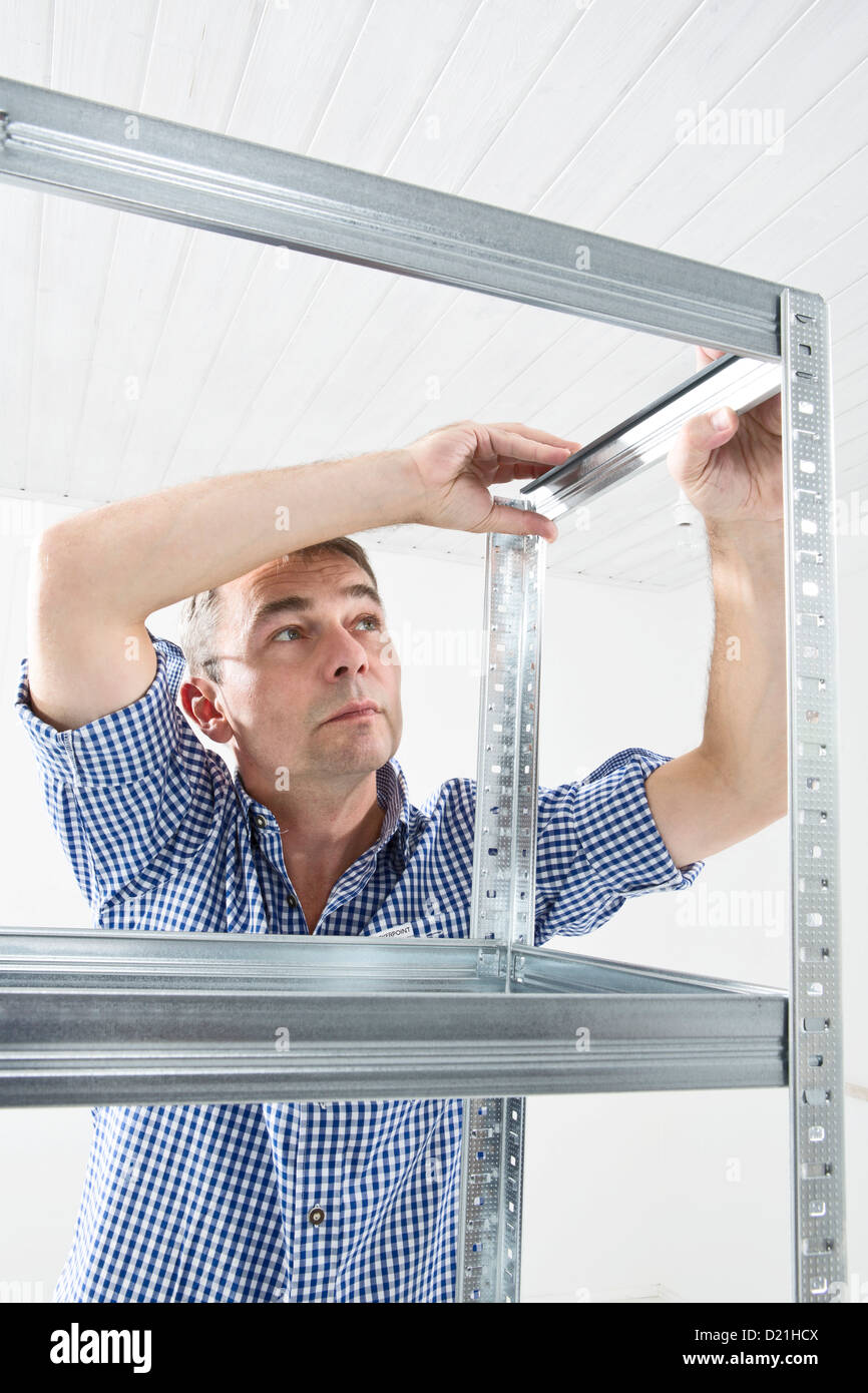 Mature man building shelf Stock Photo - Alamy