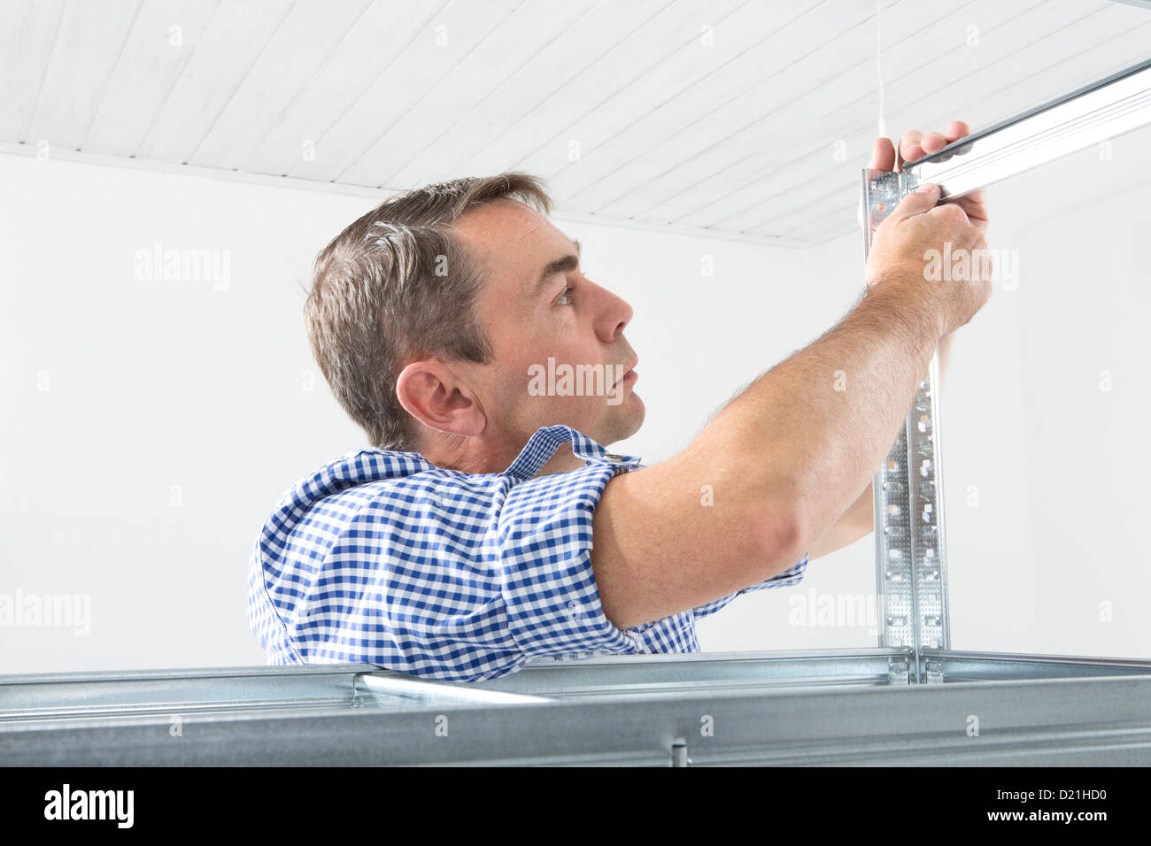 Mature man building shelf Stock Photo - Alamy