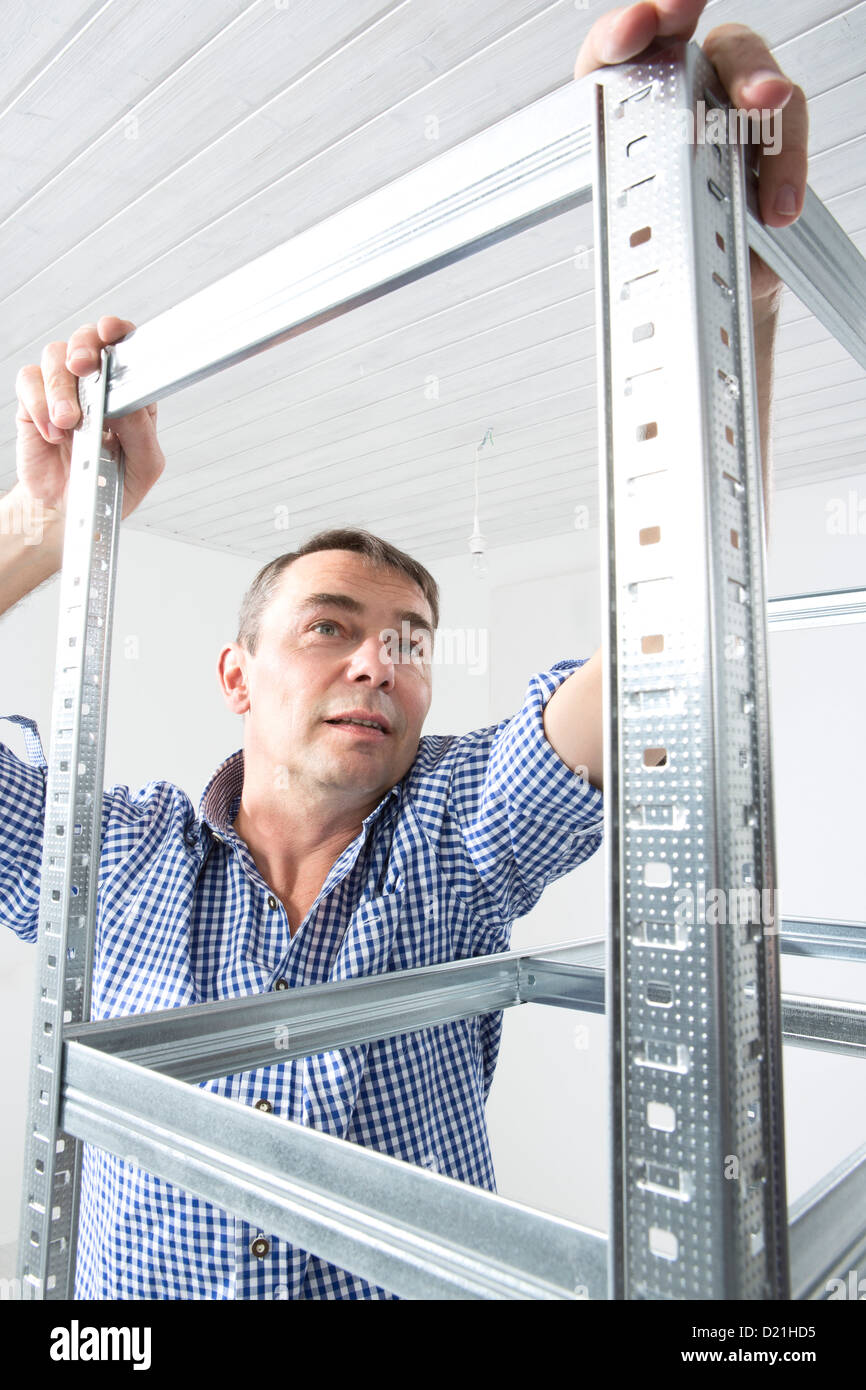 Mature man building shelf Stock Photo - Alamy