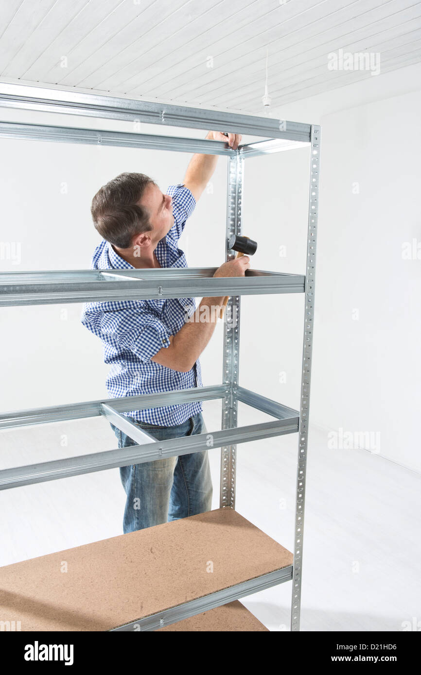 Mature man building shelf Stock Photo - Alamy
