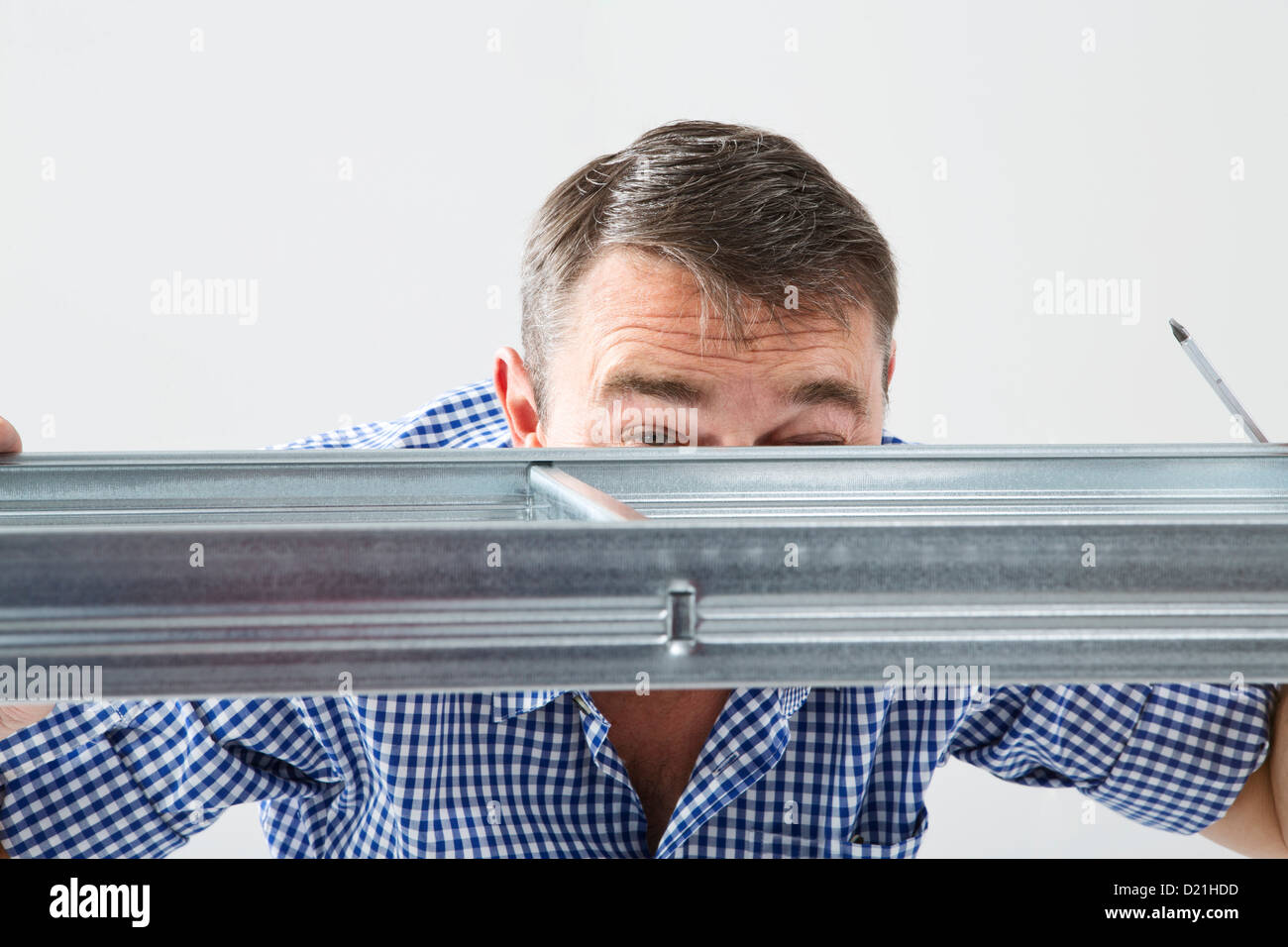 Mature man building shelf Stock Photo - Alamy