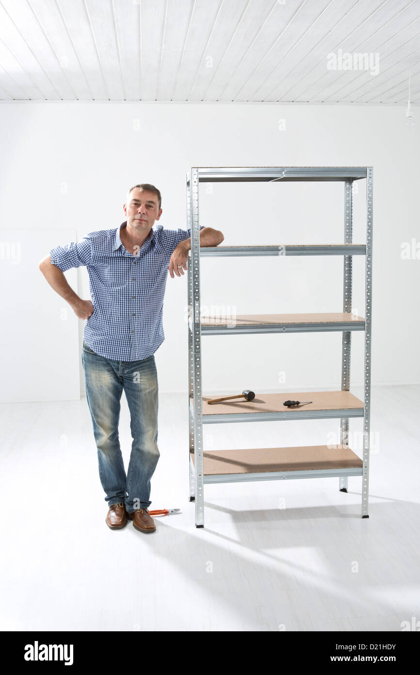 Mature man building shelf Stock Photo - Alamy