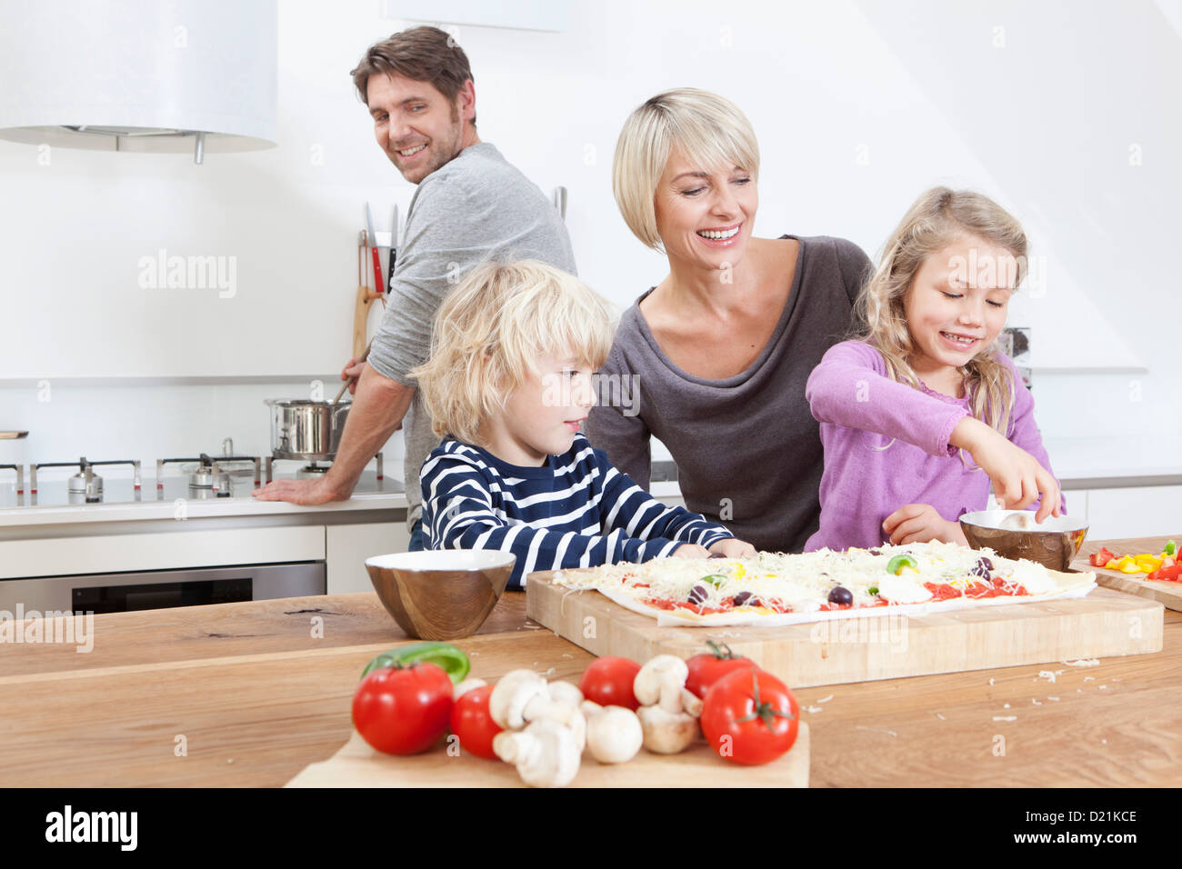 Germany, Bavaria, Munich, Family preparing pizza in kitchen Stock Photo ...
