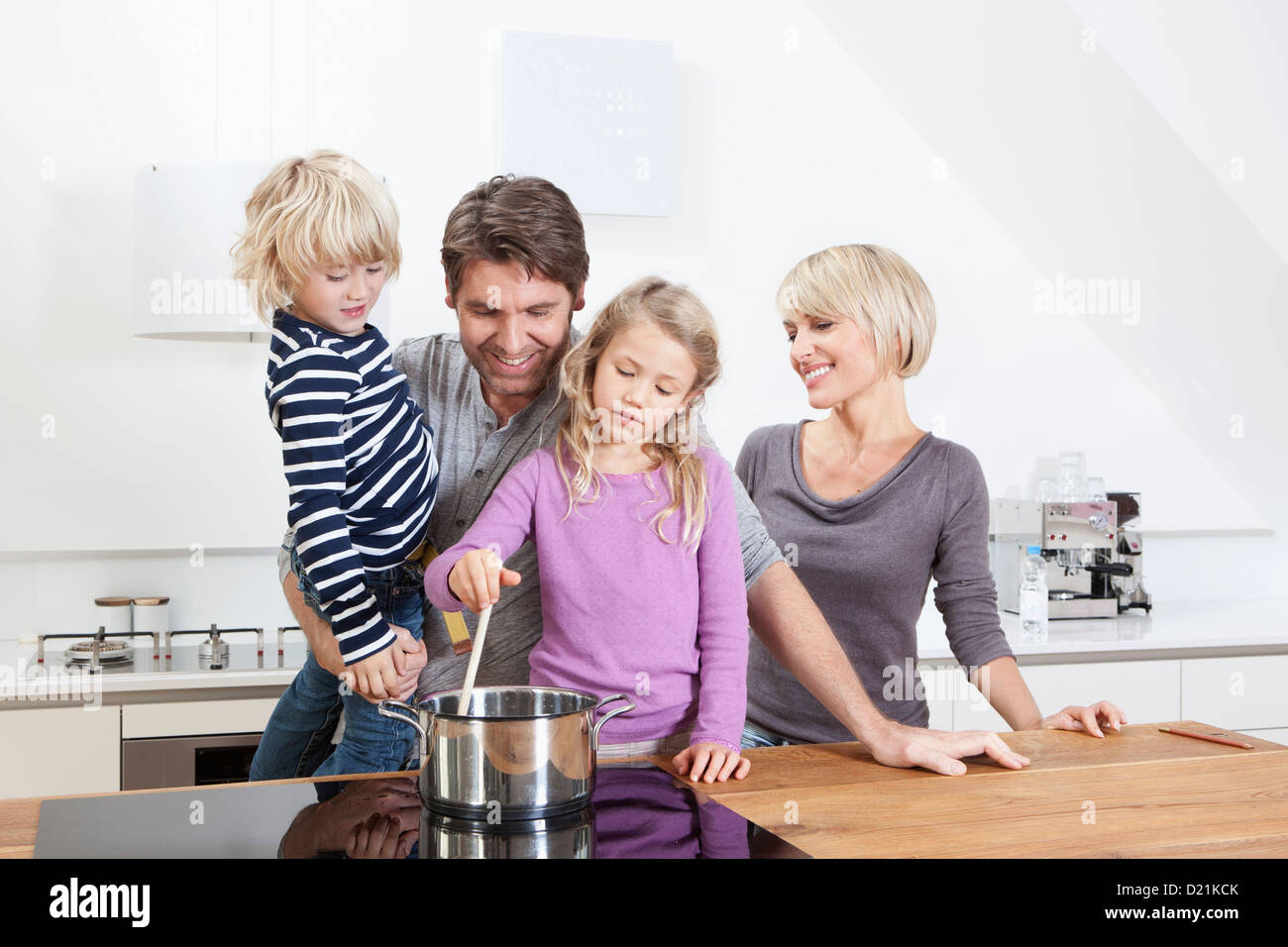 Germany, Bavaria, Munich, Family preparing food in kitchen Stock Photo ...