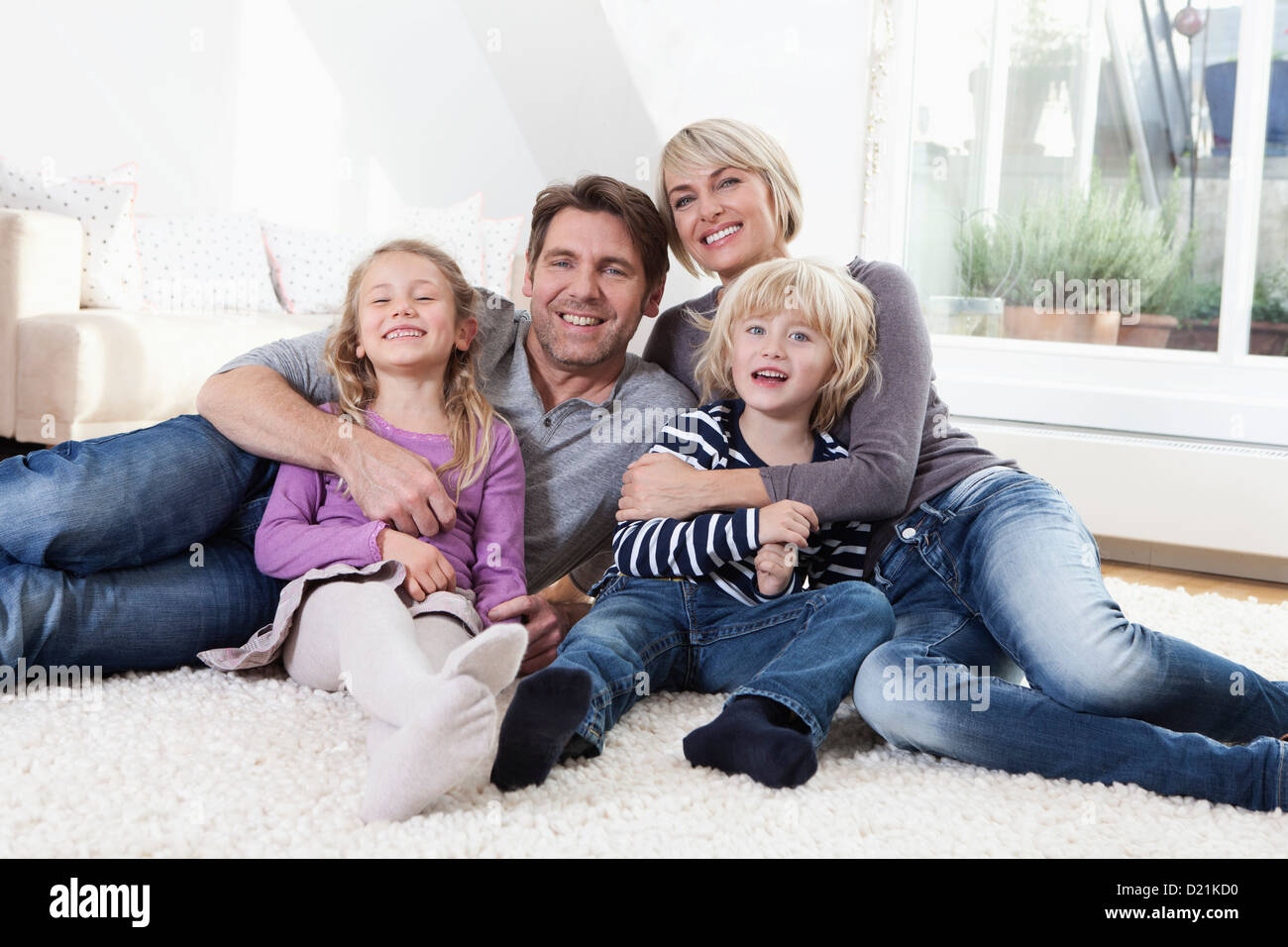 Germany, Bavaria, Munich, Family lying on floor, portrait, smiling ...