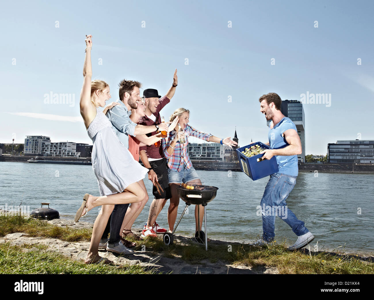 Germany, Cologne, Group of people gathered around barbecue Stock Photo ...