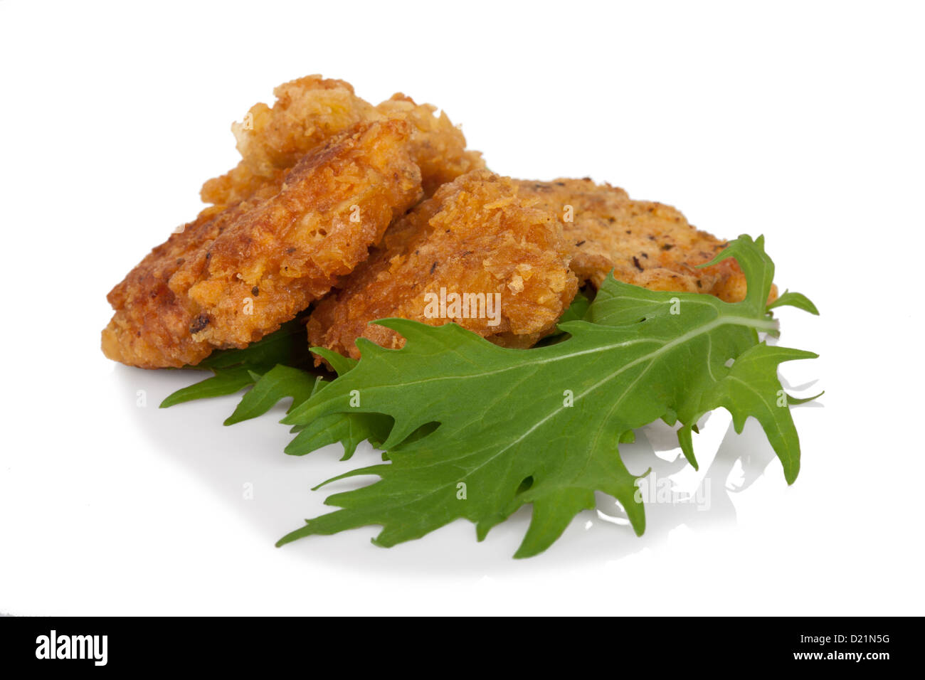 Breaded chicken sticks with mitsuna salad leaves isolated on white ...
