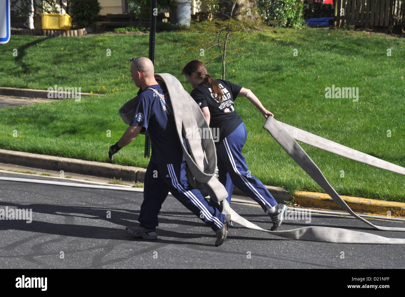 Firefighters drag a hose back to a fire truck after a fire was ...