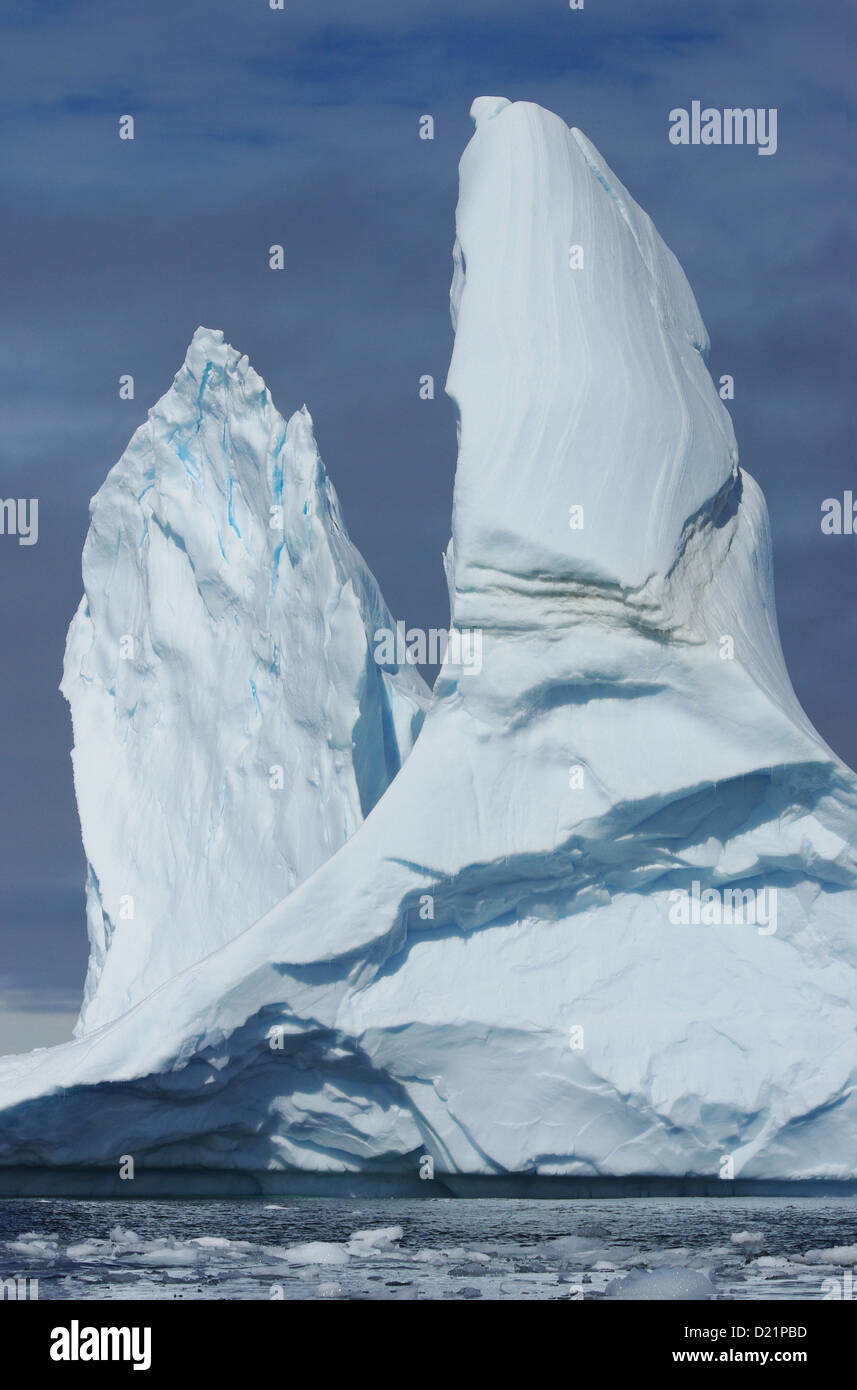 A large iceberg with two peaks floating in the ocean Stock Photo - Alamy