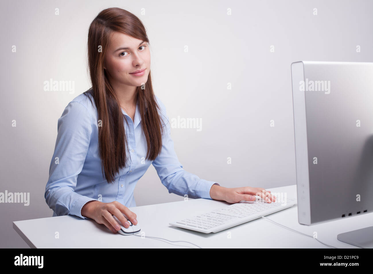 Beautiful woman in blue shirt working on a computer Stock Photo - Alamy