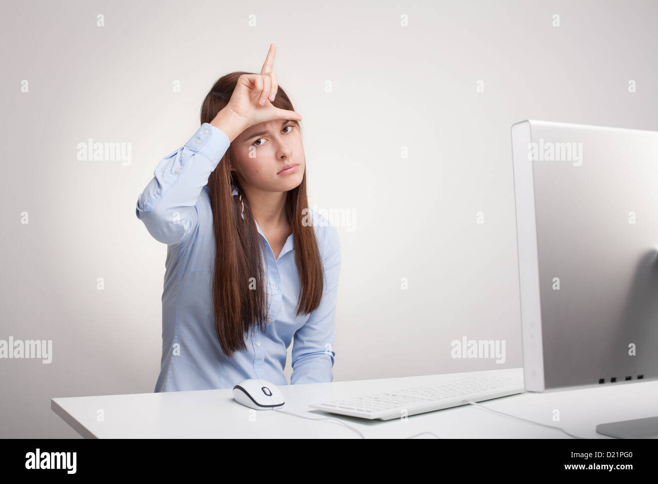 Woman in office is showing loser sign Stock Photo - Alamy