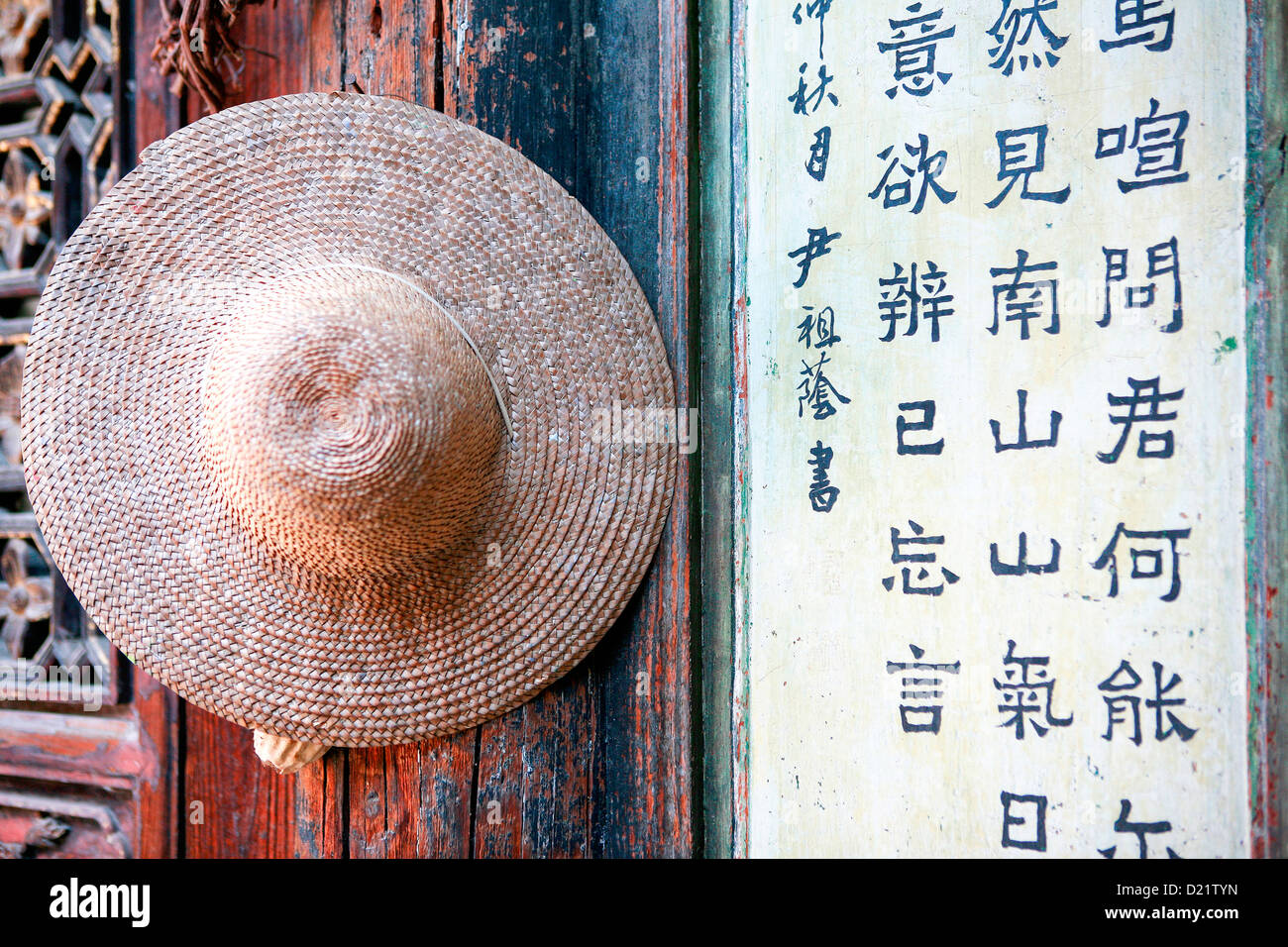 A traditional Chinese straw hat hanging in a doorway at the village of ...