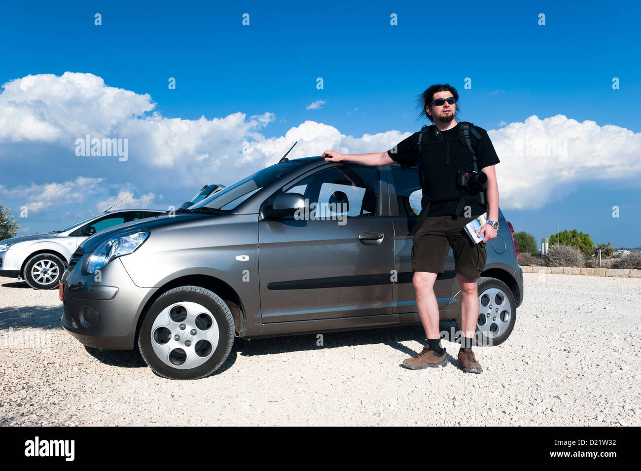 Young man standing next to his car Stock Photo - Alamy