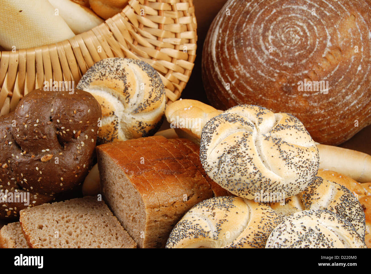 Various fresh baked goods with a basket and a wheat grain Stock Photo ...