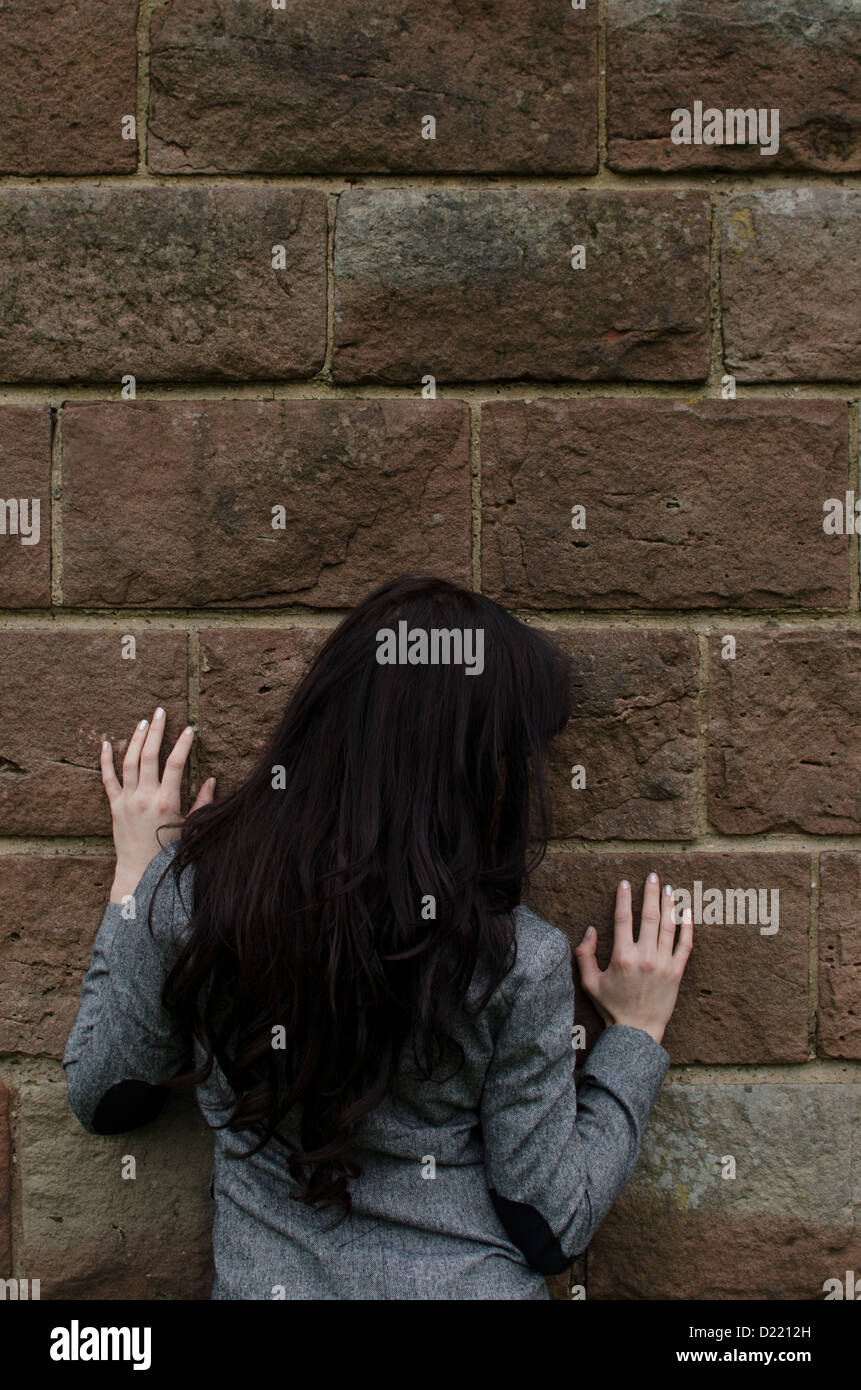 Woman leaning against the wall Stock Photo - Alamy
