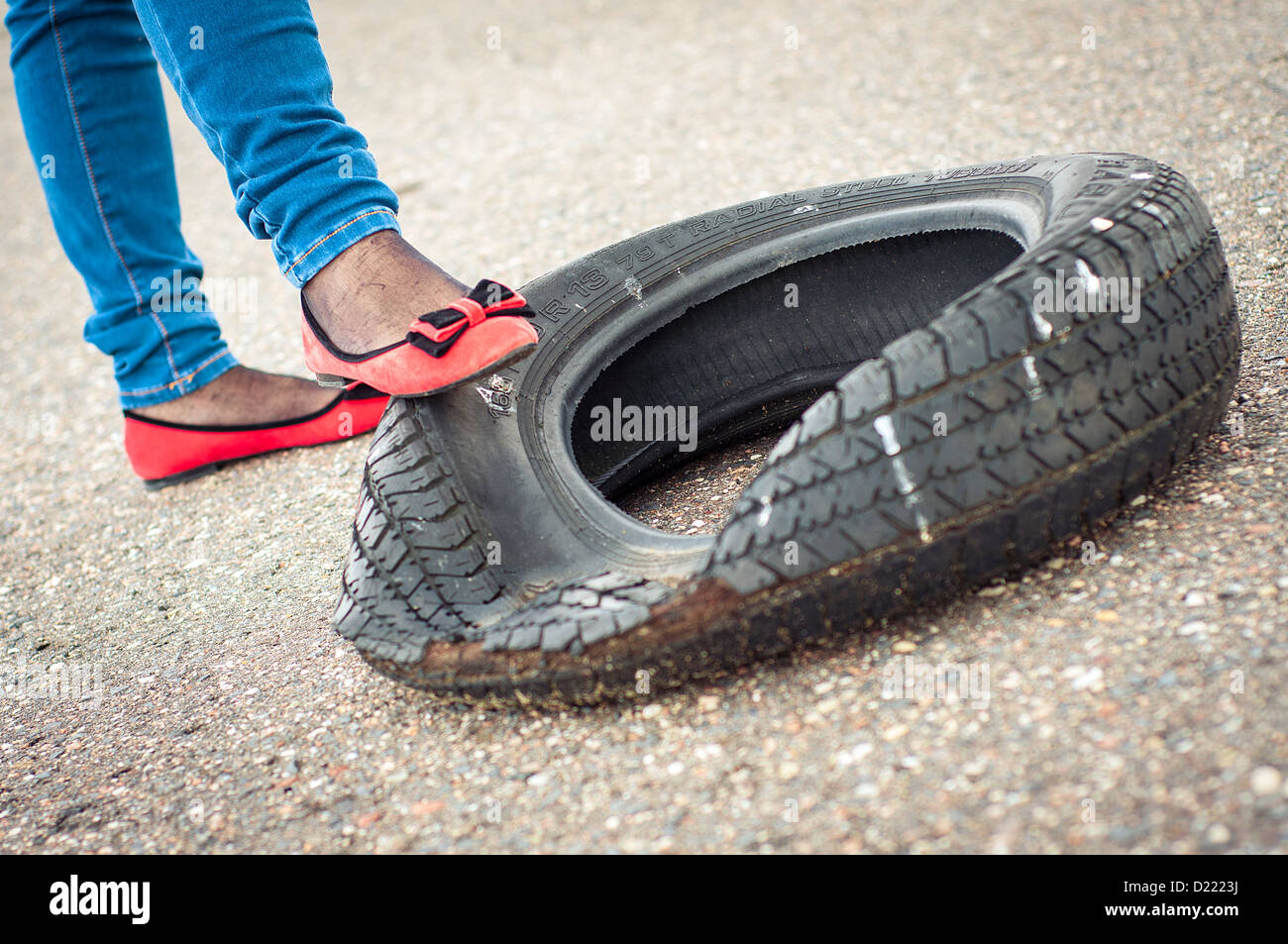 Wrecked old tire on the street and girls foot on it Stock Photo - Alamy
