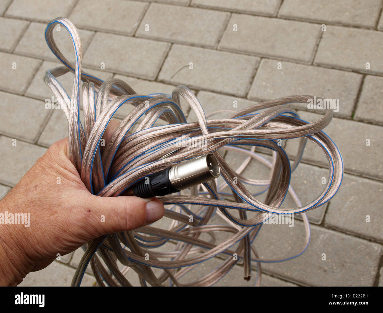 Hand holding bunch of audio cable with connector Stock Photo - Alamy