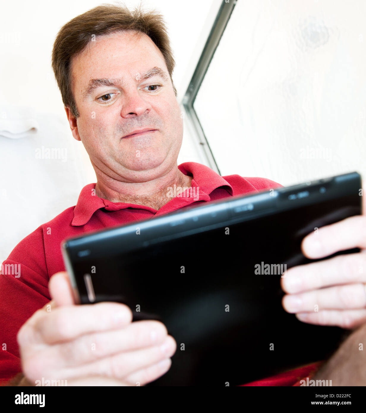 Man in the bathroom using a tablet PC while on the toilet Stock Photo ...