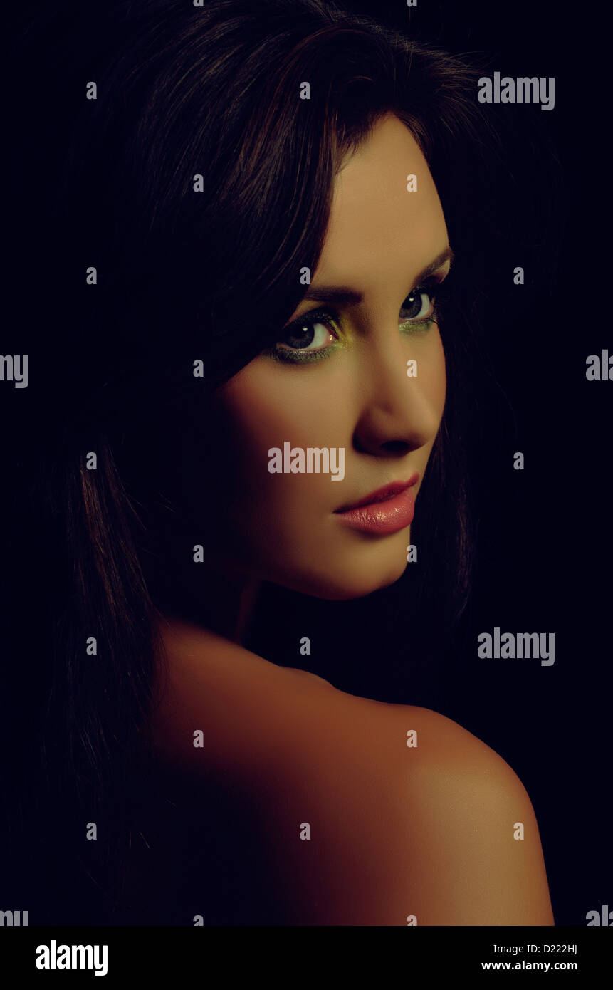 Beautiful young woman looking over shoulder Stock Photo - Alamy