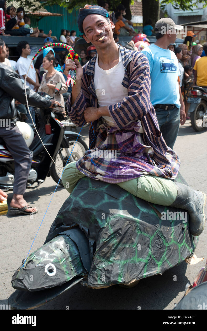 A man riding a turtle takes part in a Harvest Festival parade in the ...