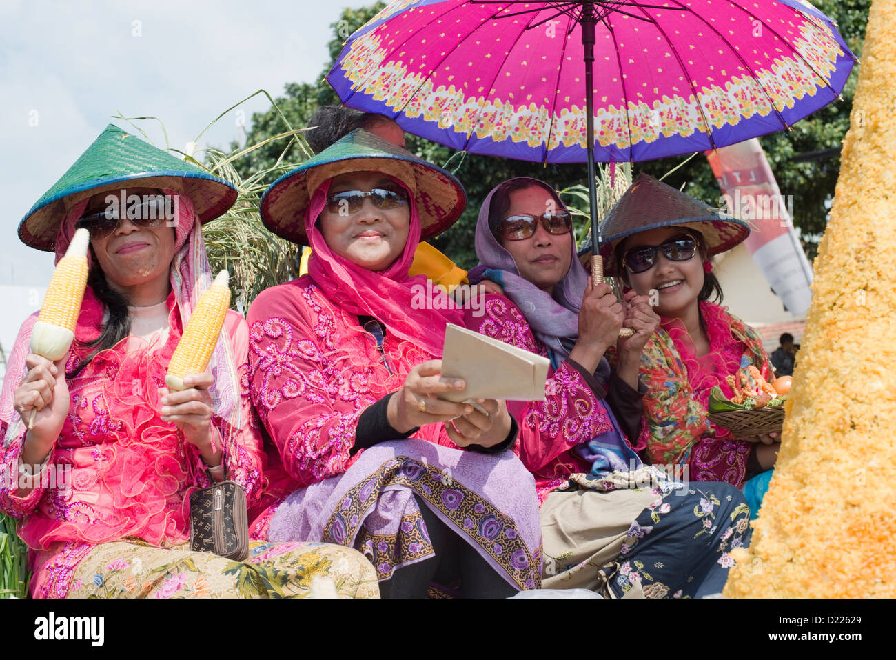 A group of women sit atop their float in a Harvest Festival parade in ...