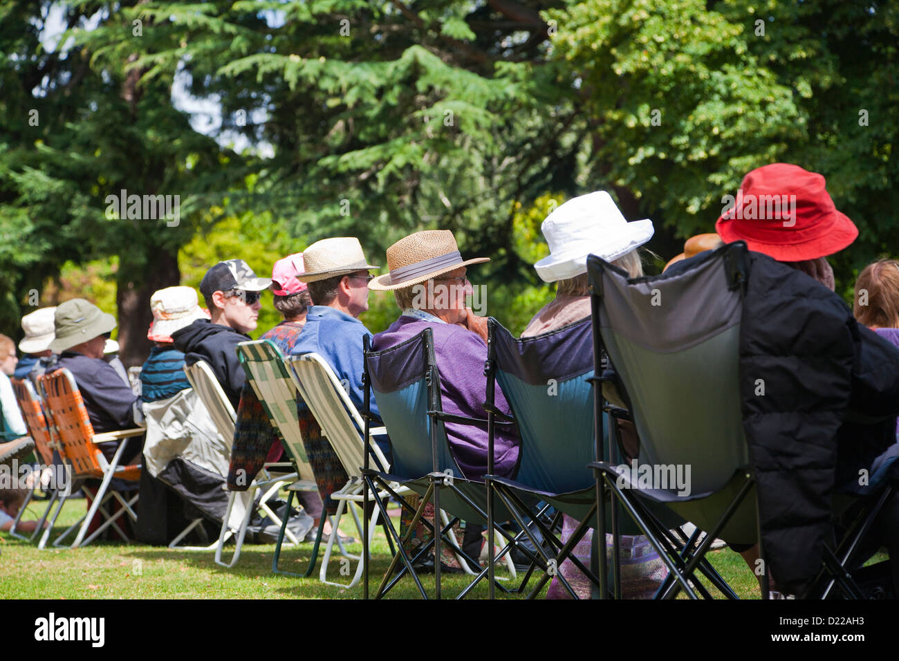 A row of people sitting, wearing hats, watching entertainment. Hagley ...