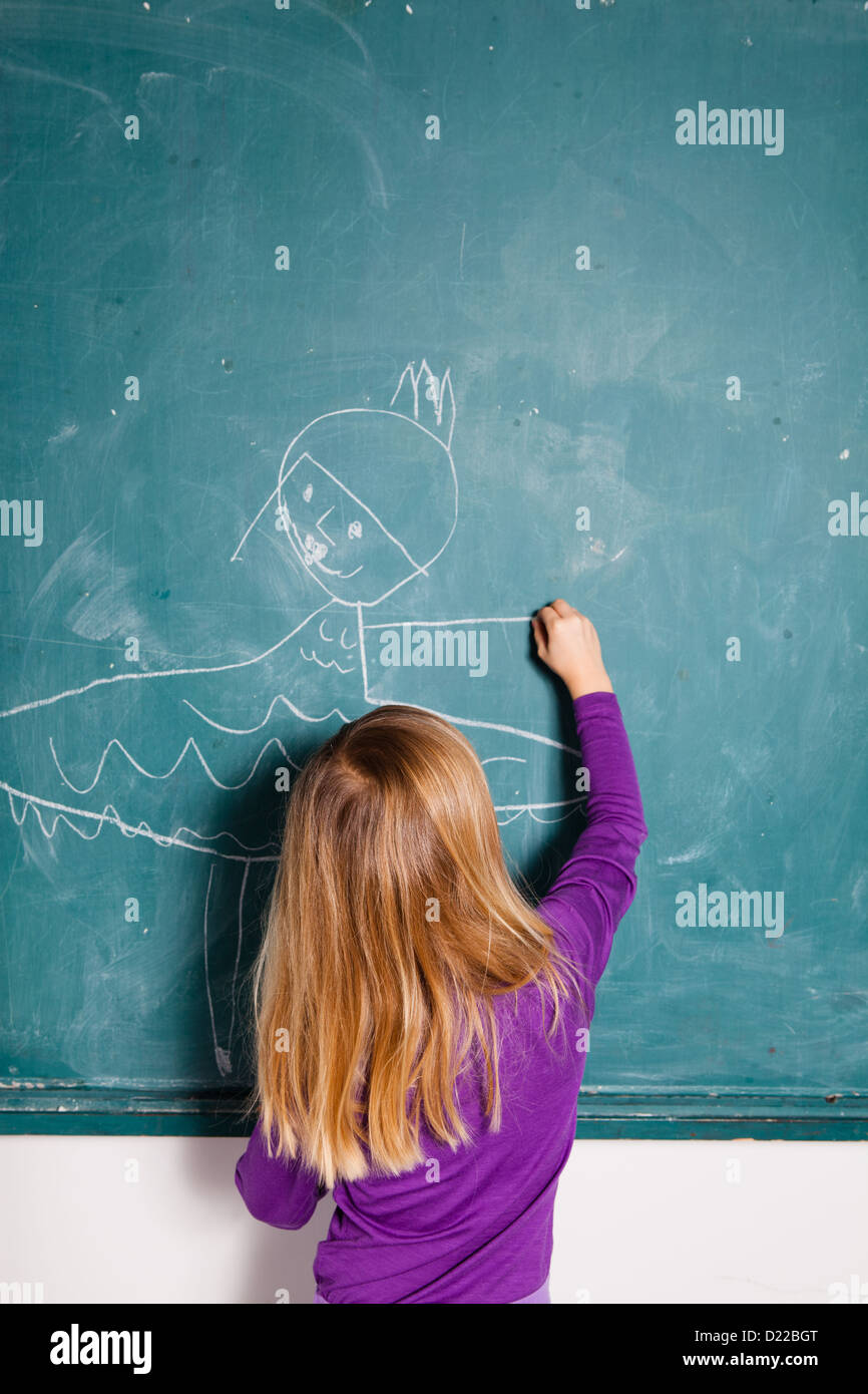 Studio portrait of young girl in classroom drawing image of girl in ...