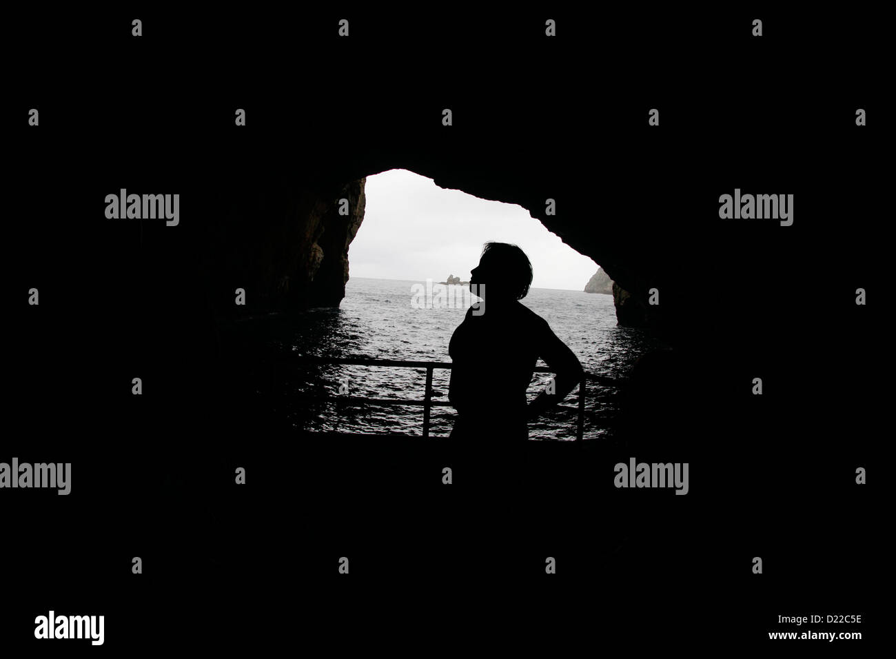 A silhouette of a lady from a dive boat inside a cave look out Stock ...