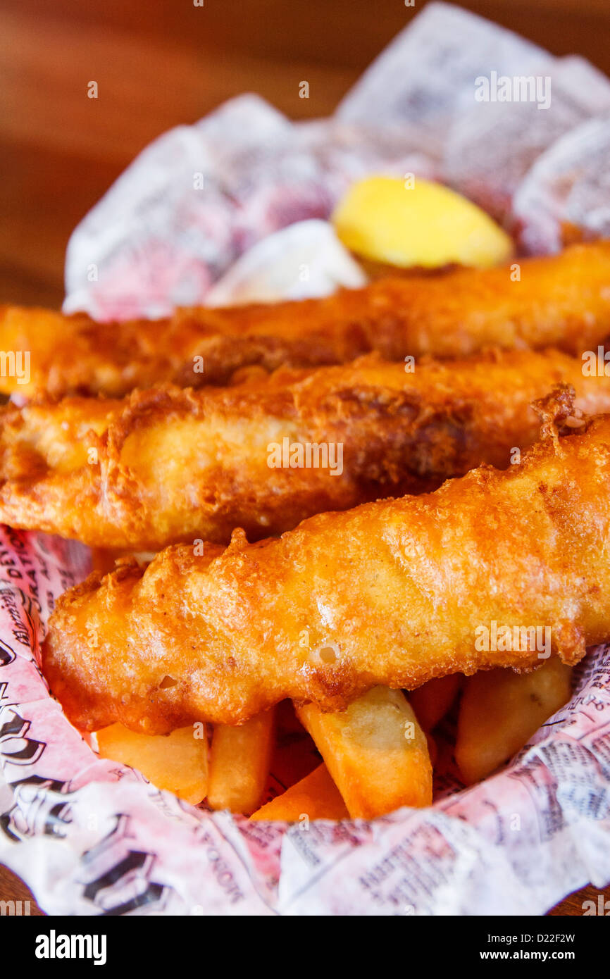 A serving of fresh fried fish and chips in a basket ready for lunch ...