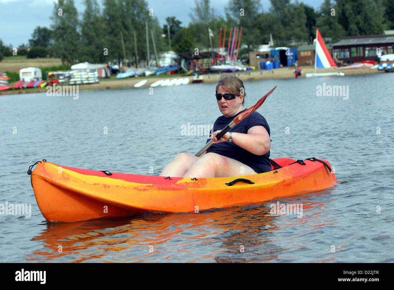 Mature woman enjoying a Kayak in an inshore lake with boating school in ...